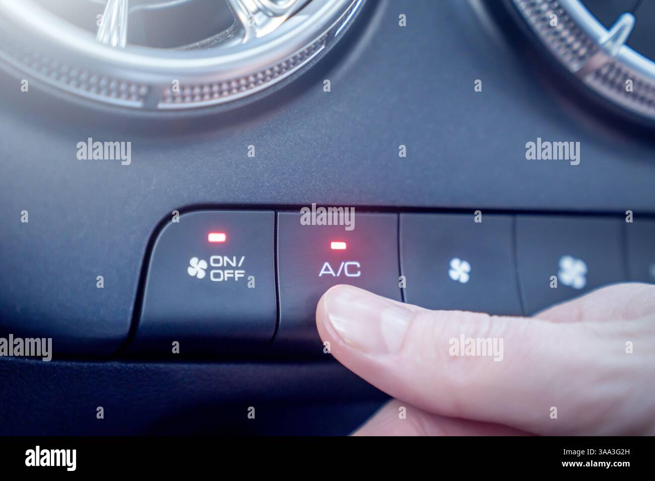 A hand skillfully adjusting the air conditioning button located in a ...