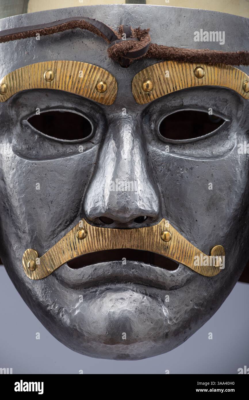 Historical metallic combat helmet with integrated face mask. Pointed ...