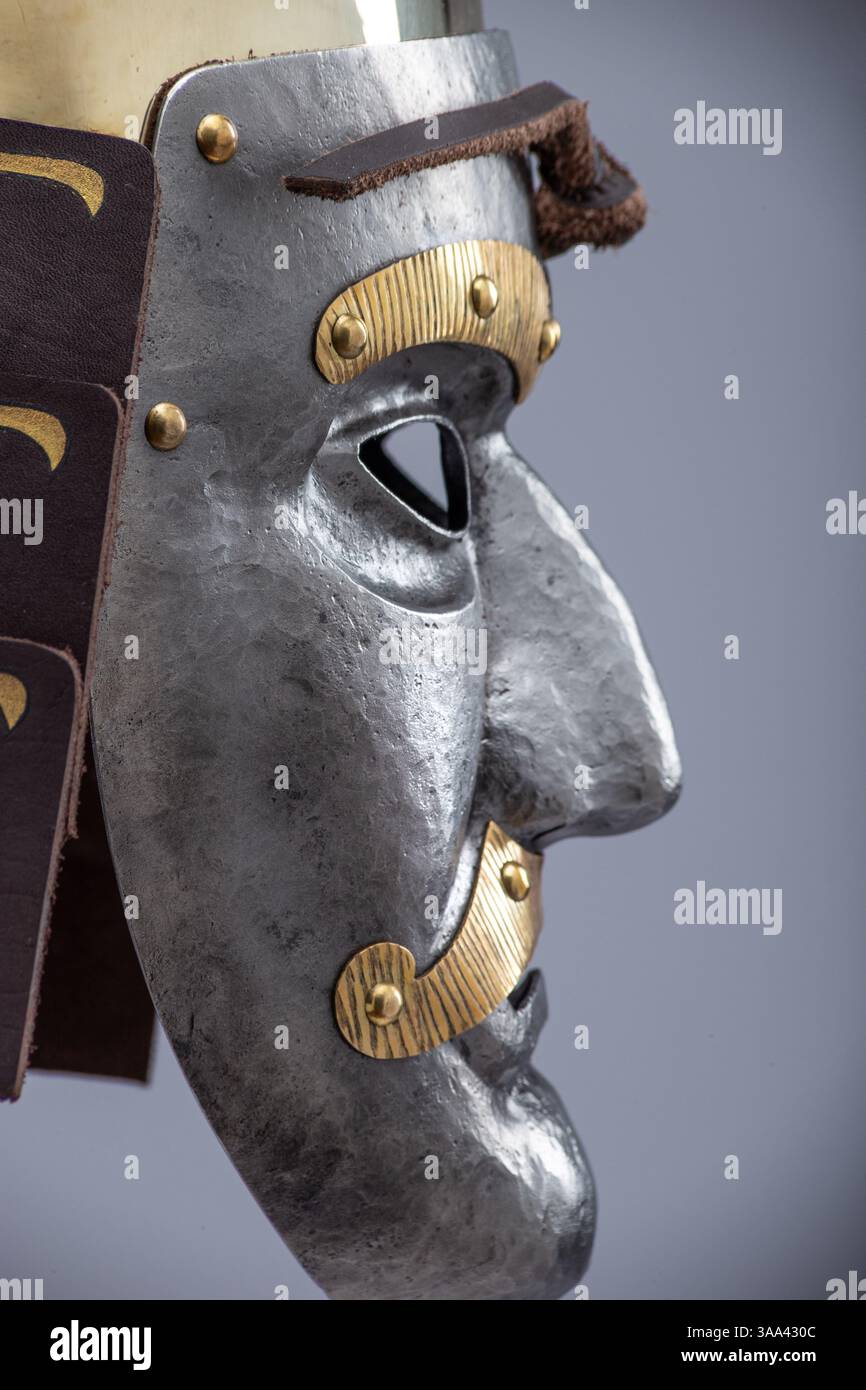 Historical metallic combat helmet with integrated face mask. Pointed ...