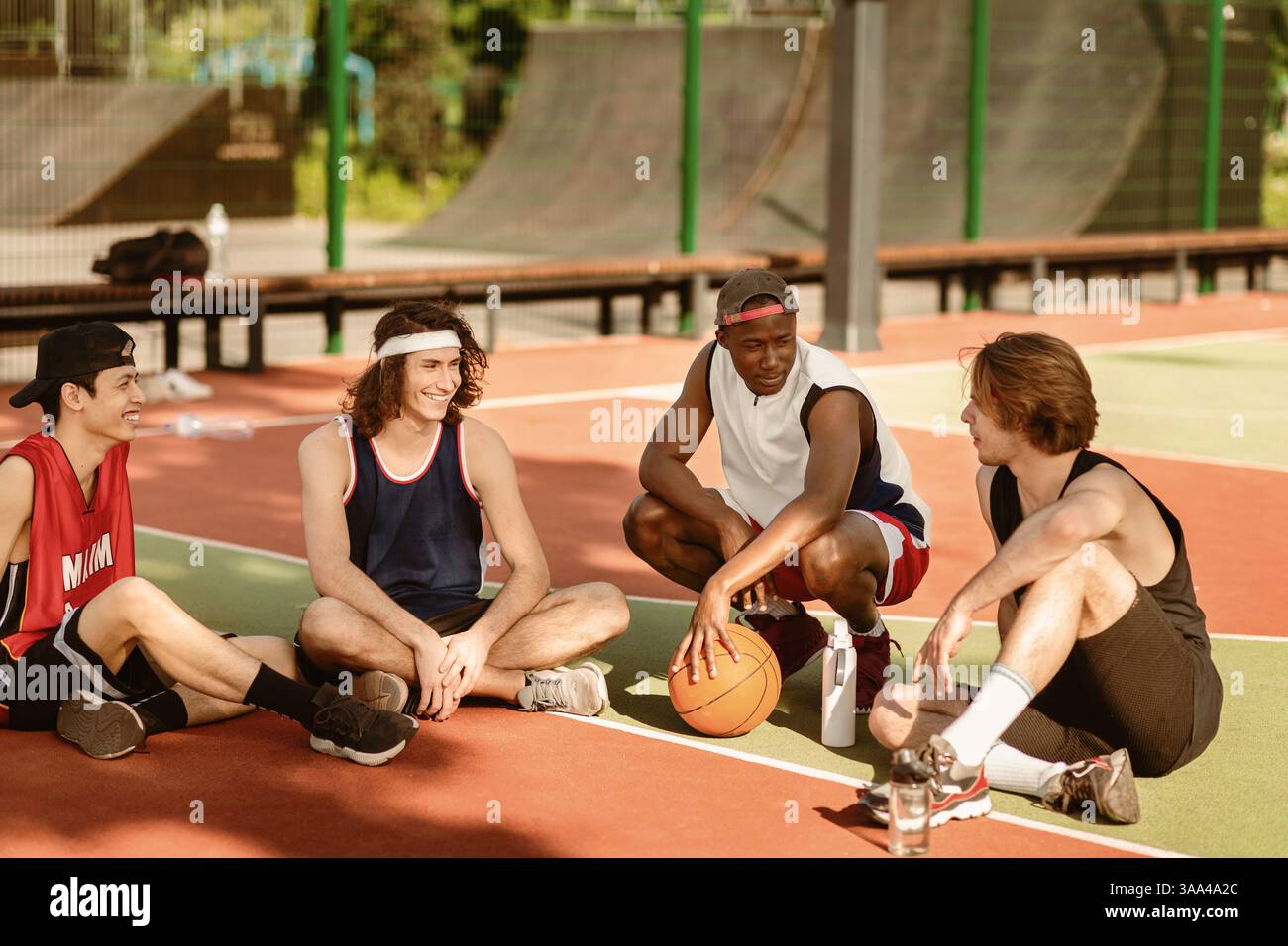 Group of multiracial basketball players resting after game match at ...