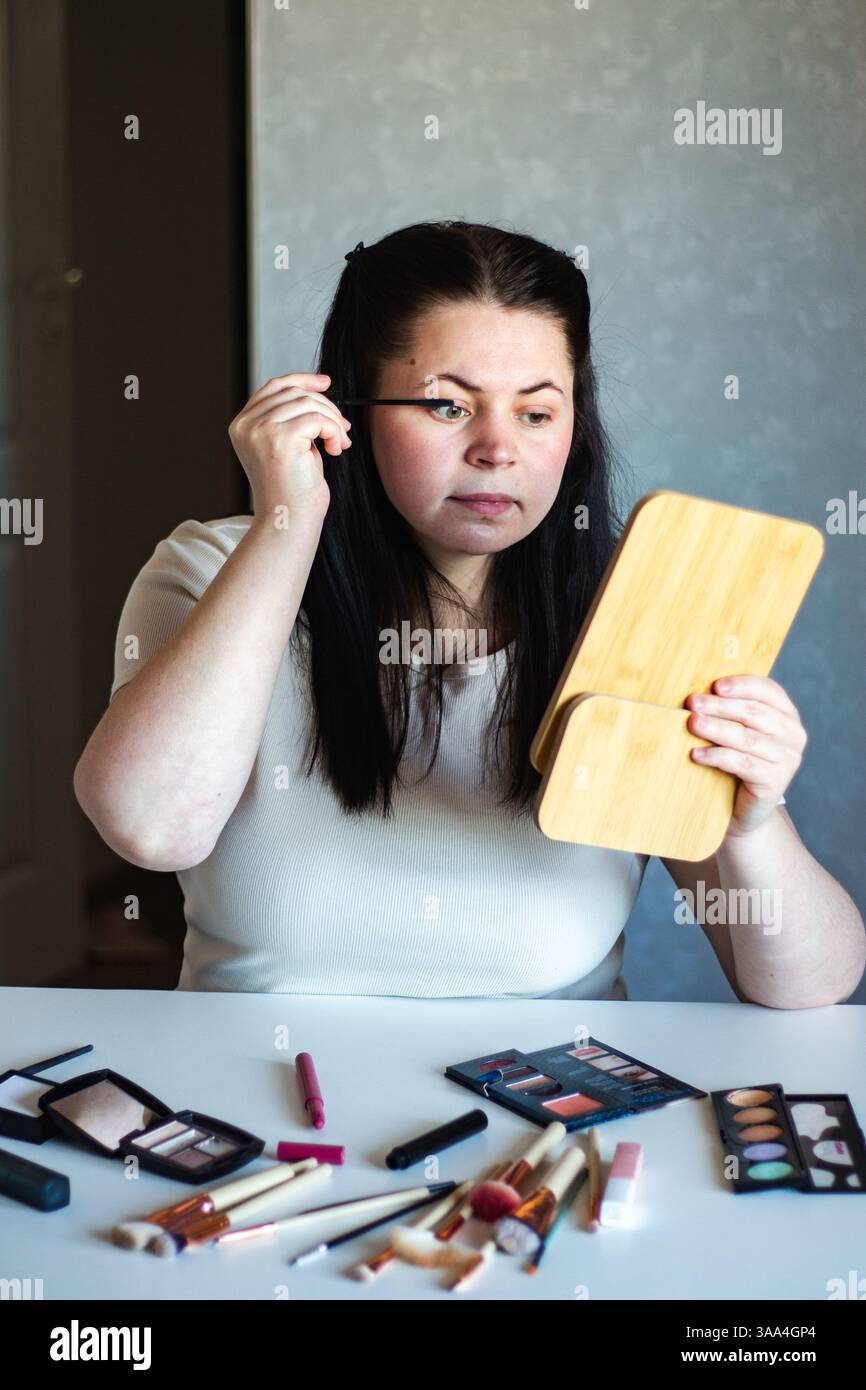 Vertical image of Millennial Caucasian woman doing self make up ...