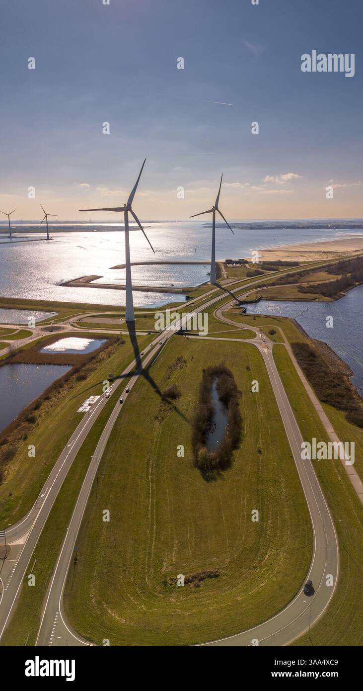 A scenic aerial view of a coastal wind farm with multiple wind turbines ...