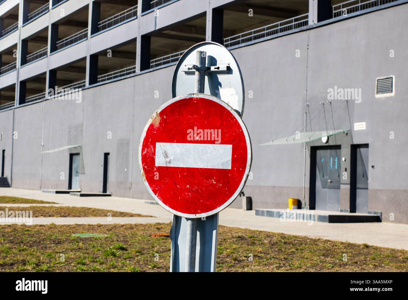 A striking red no entry sign juxtaposed with a modern building faade ...