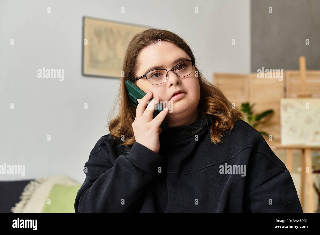 Young woman with Down syndrome engages in a meaningful phone call while ...