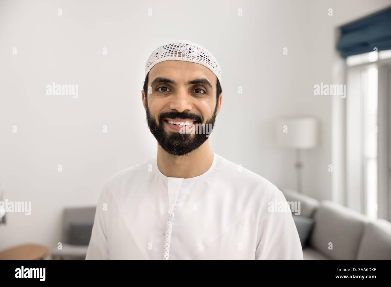 Cheerful Arabic man posing in living room Stock Photo - Alamy