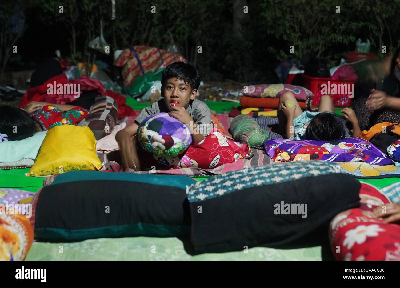 Nay Pyi Taw, Myanmar. 31st Mar, 2025. Earthquake-affected children rest in woods by a road in ...