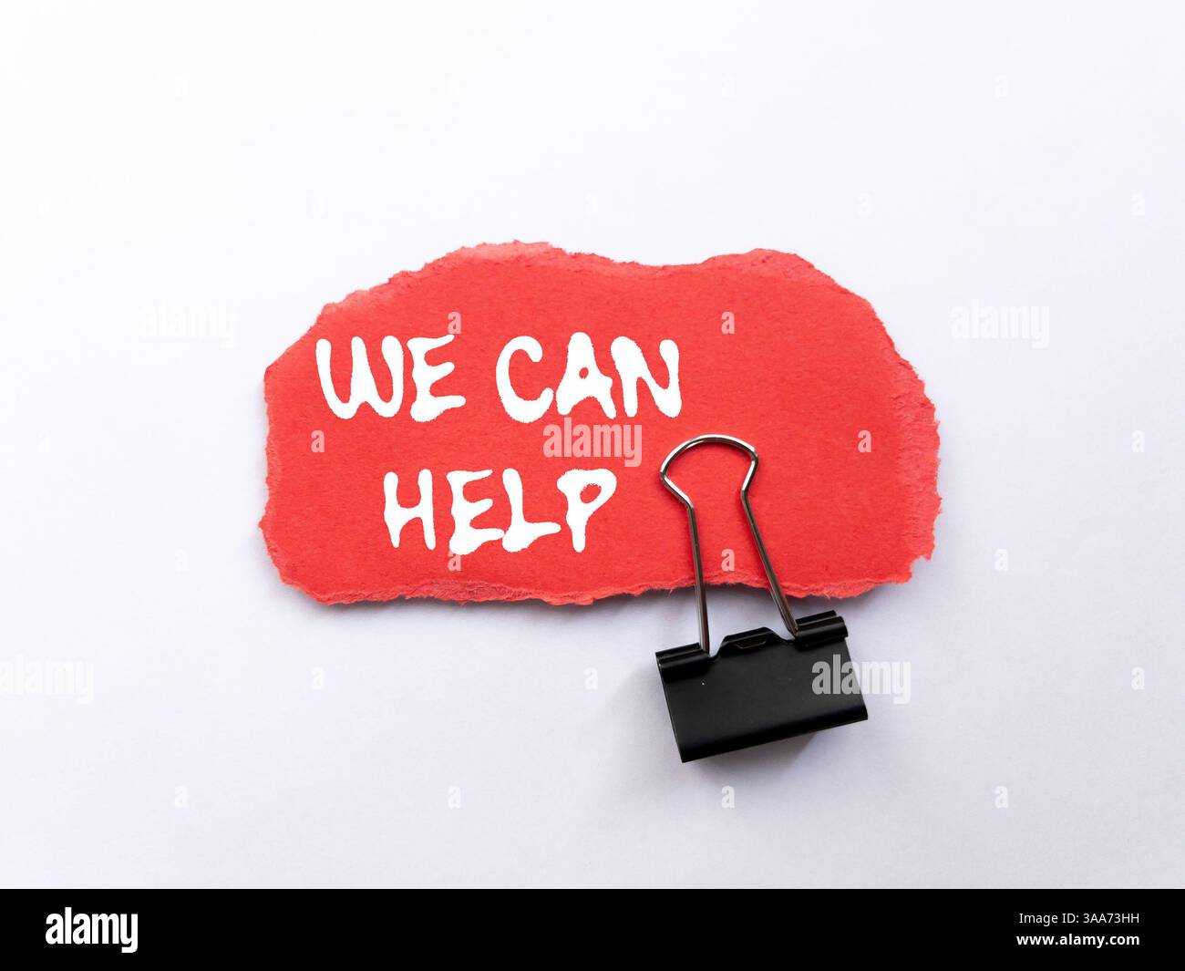 We can help message written on ripped torn red paper piece on white background. Conceptual we ...