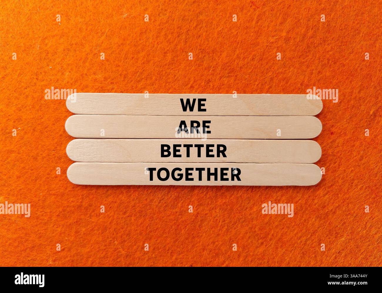 We are better together message written on wooden sticks on orange background. Conceptual we are ...