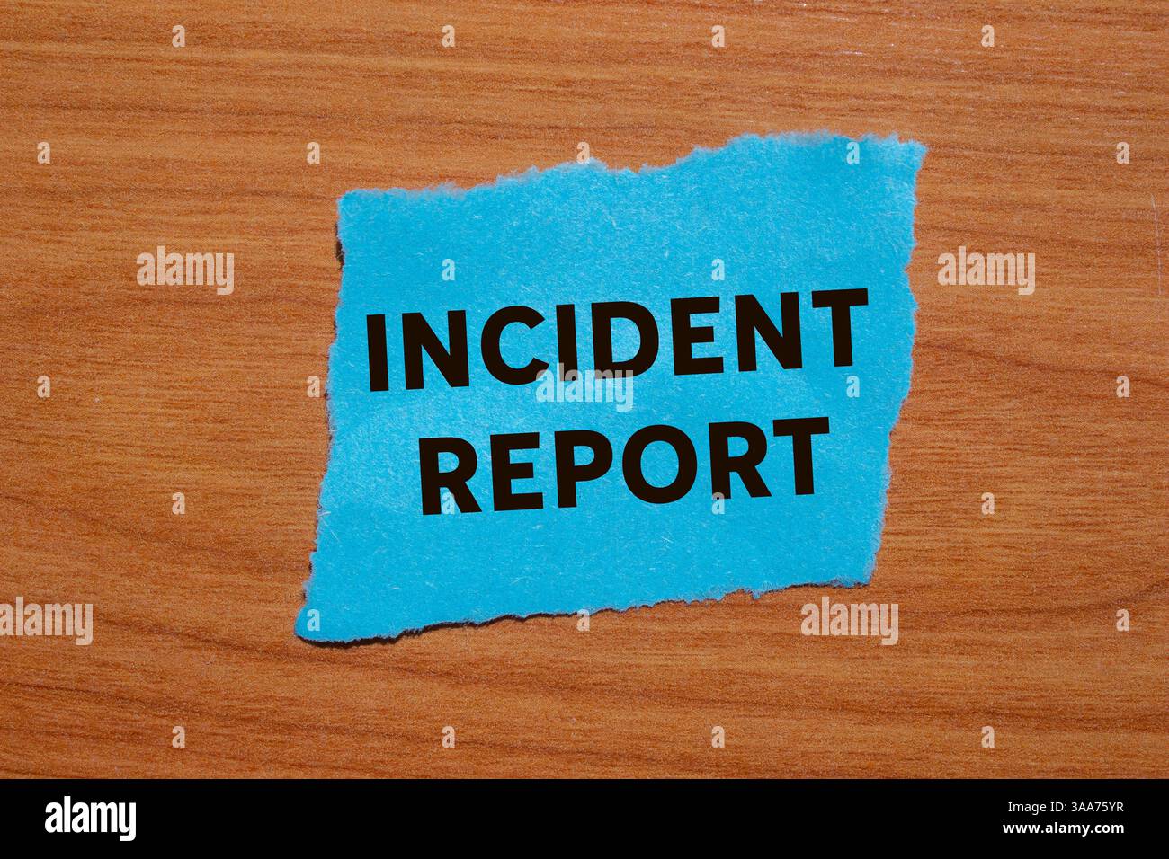 Incident report message written on ripped torn blue paper piece on ...