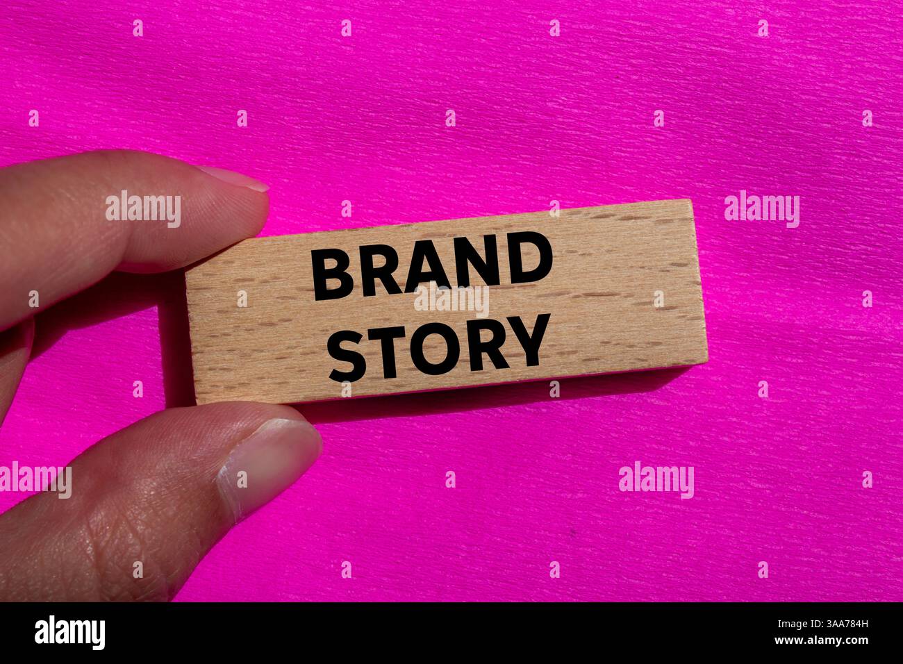 Brand story message written on wooden block on pink background ...