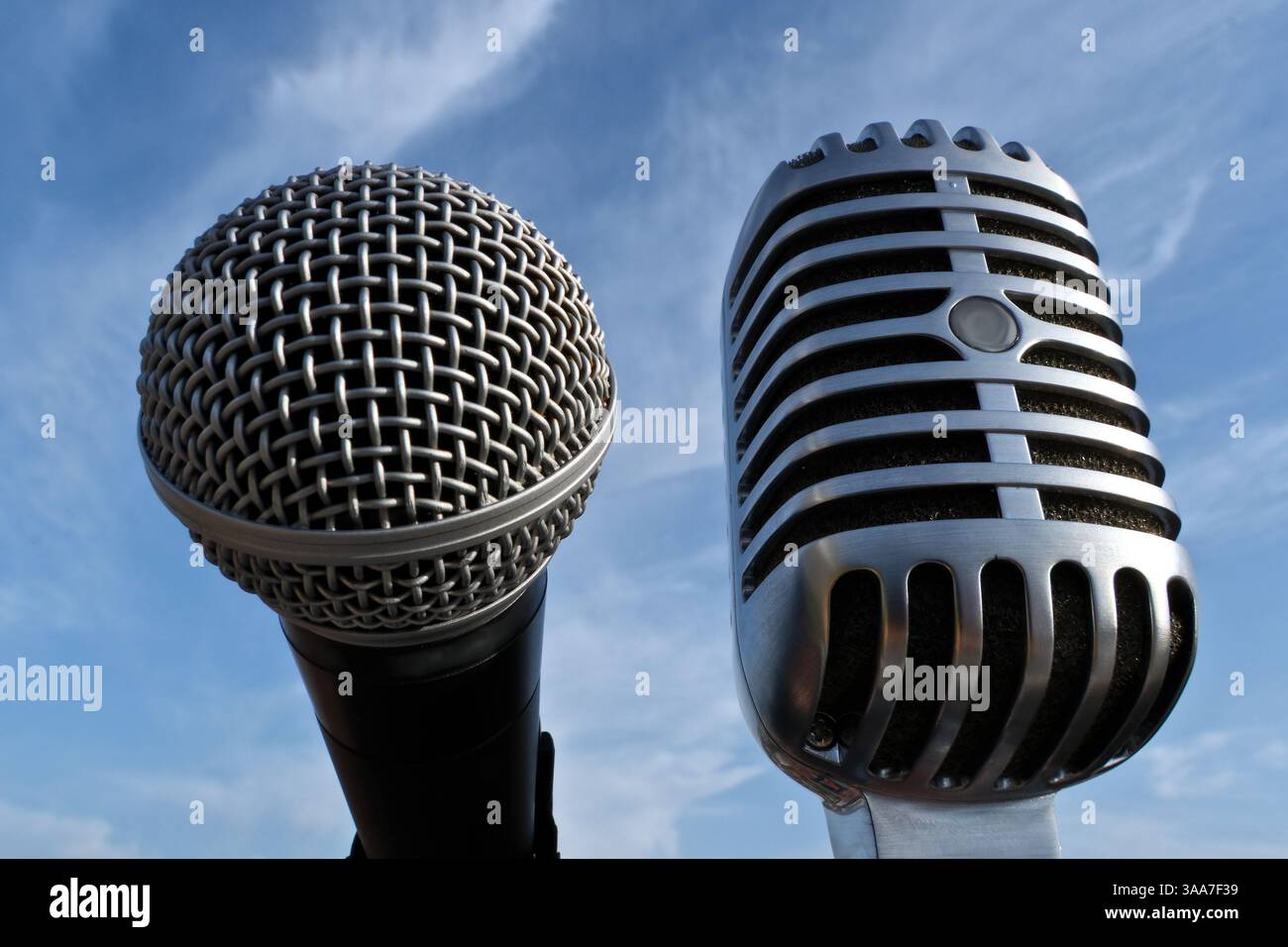 Two microphones on the background of the blue sky and white clouds ...