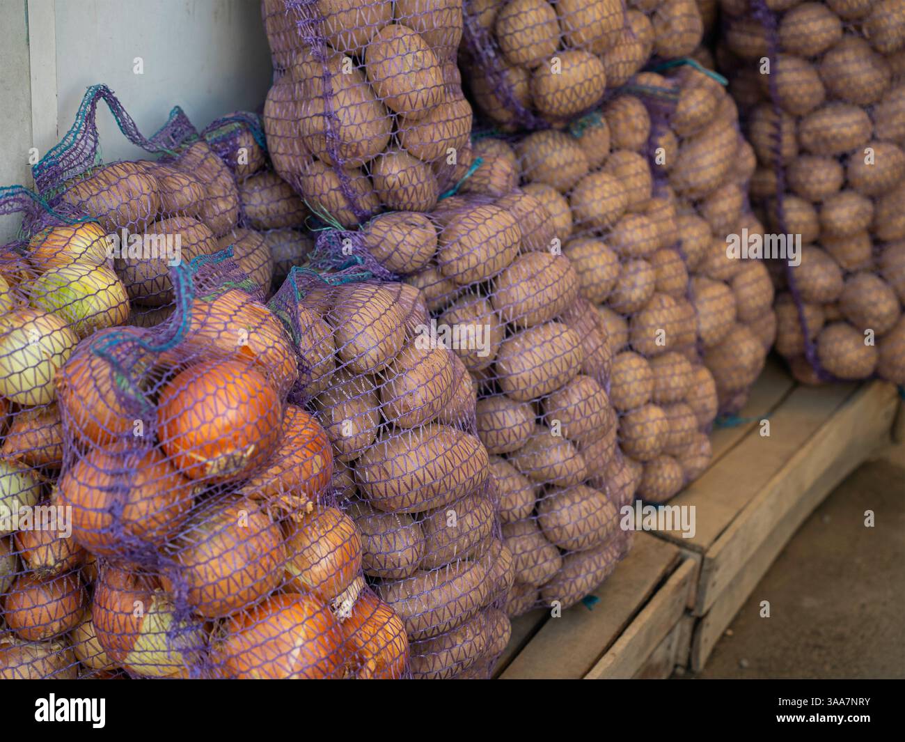 Natural healthy new potatoes and onions in mesh bags are sold at the ...