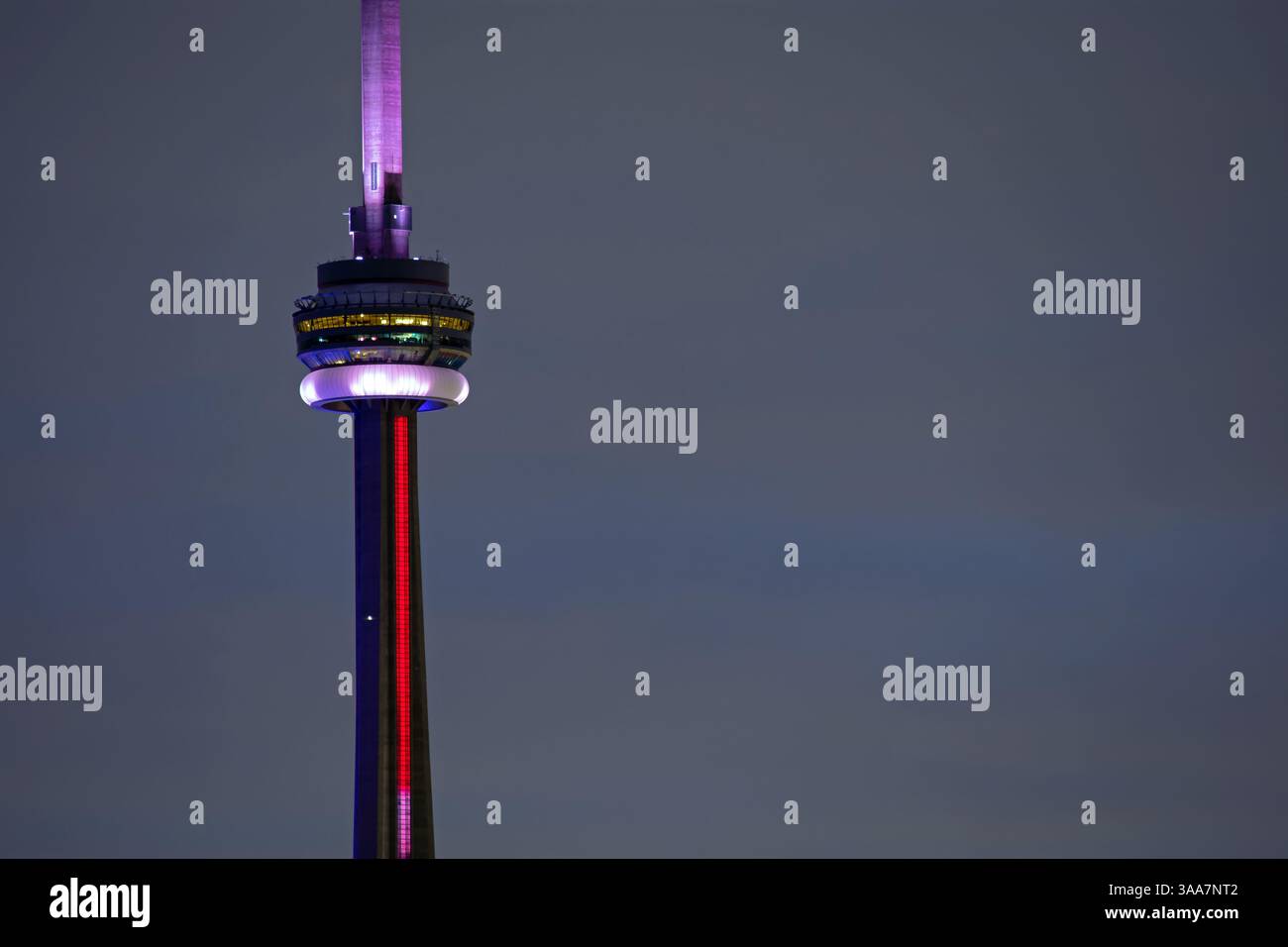 Toronto's CN Tower observation deck lit in red and purple at night ...