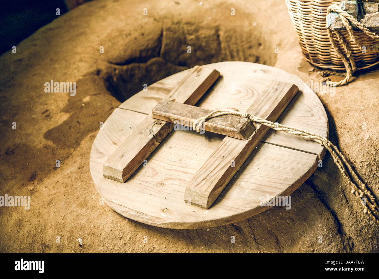 A wooden wheel with a rope tied to it. The wheel is in the shape of the ...