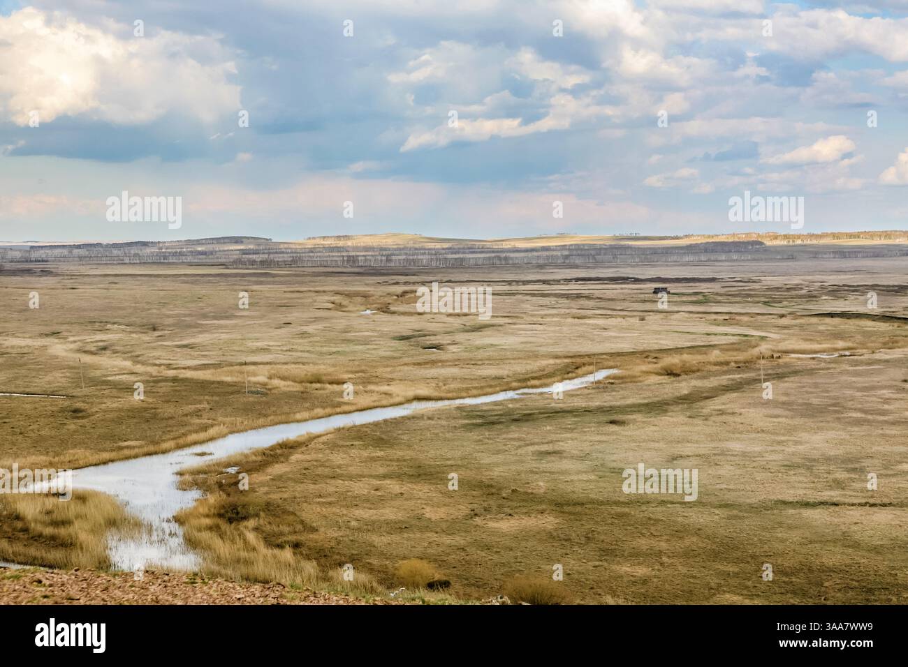 A dry, barren landscape with a river running through it. The river is ...