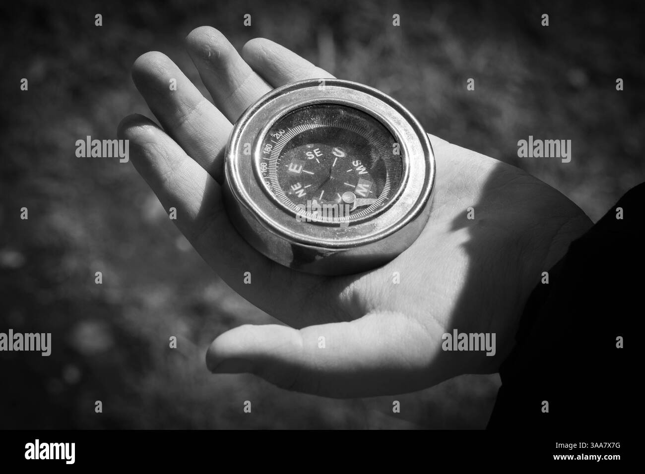 Broken compass in hands child. Black and white photo Stock Photo - Alamy