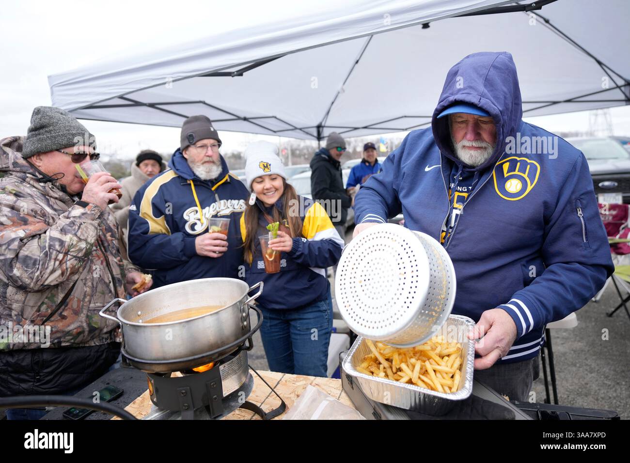 Jim Henkel, right, prepares fries while tailgating with, from left; Jim ...