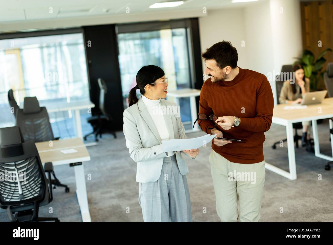 Two office professionals exchanging documents hi-res stock photography ...