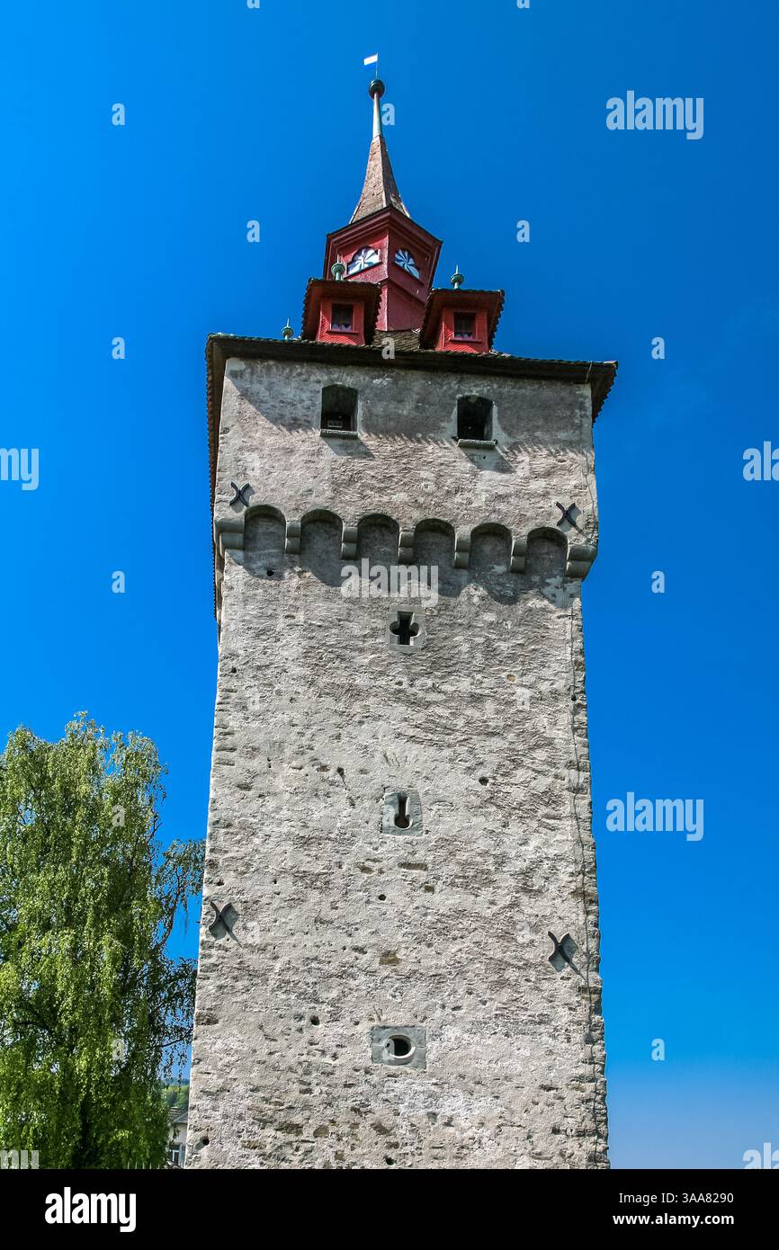 A tall tower with a red roof and a clock on top in Lucerne Switzerland ...
