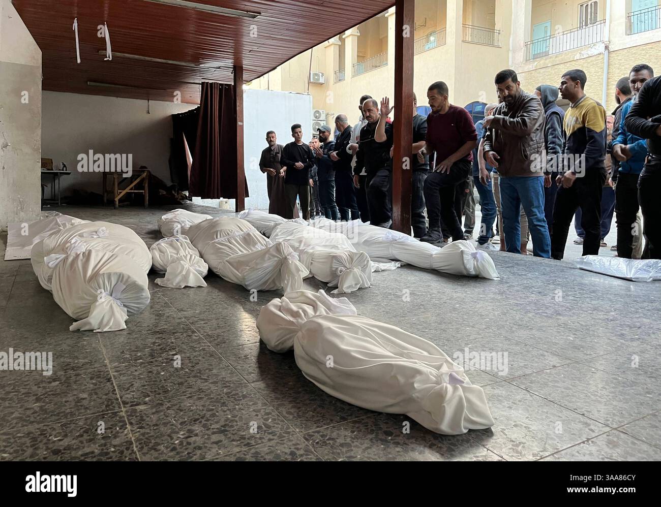 Palestinians mourn the deaths of nine members of the Hamada family at ...