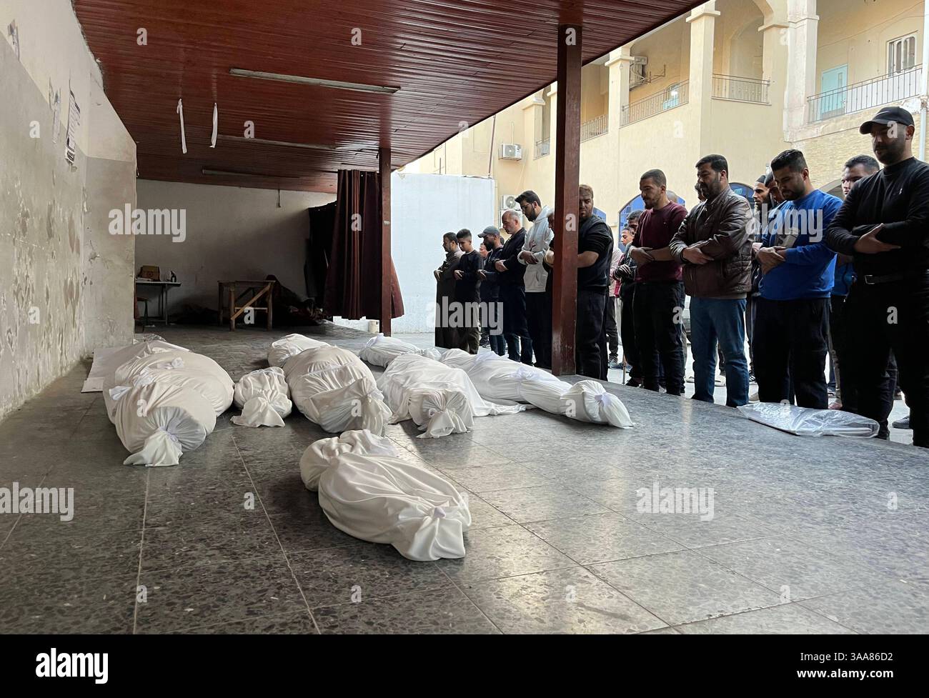 Palestinians mourn the deaths of nine members of the Hamada family at ...