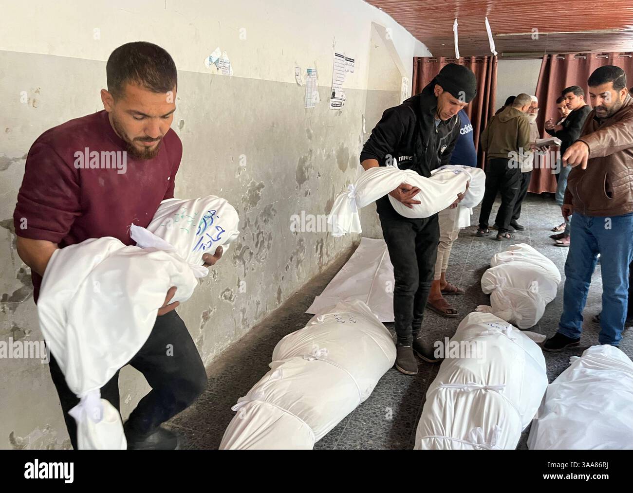 Palestinians mourn the deaths of nine members of the Hamada family at ...
