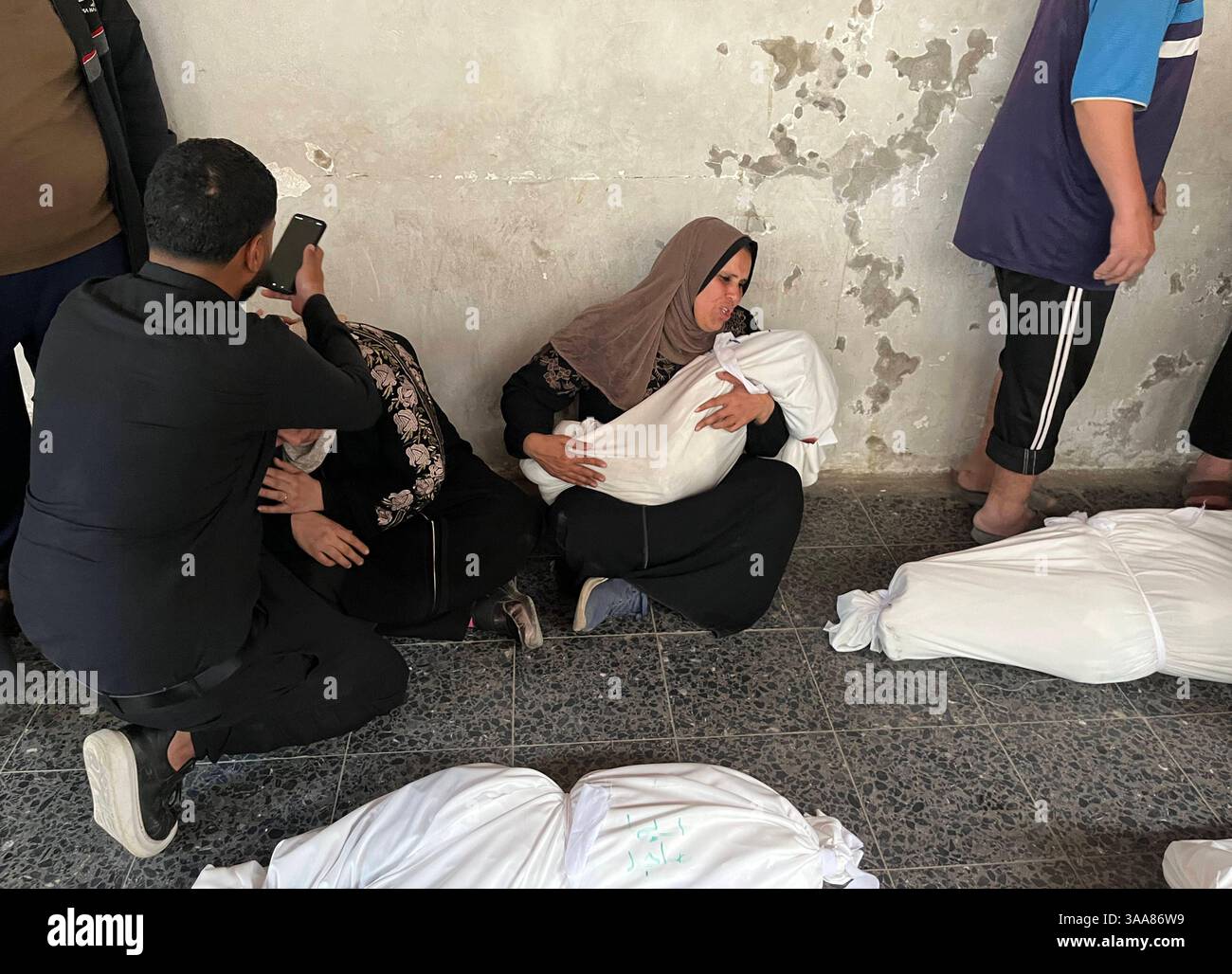 Palestinians mourn the deaths of nine members of the Hamada family at ...