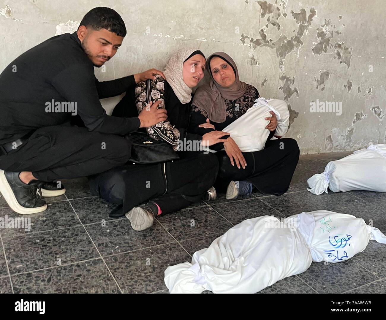 Palestinians mourn the deaths of nine members of the Hamada family at ...