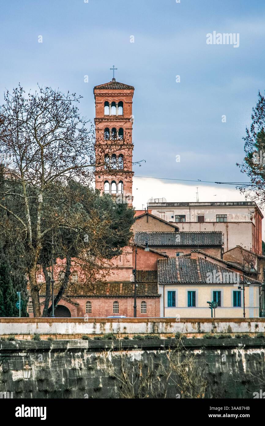 A tall red tower in Roma Italy with a cross on top. The tower is red ...