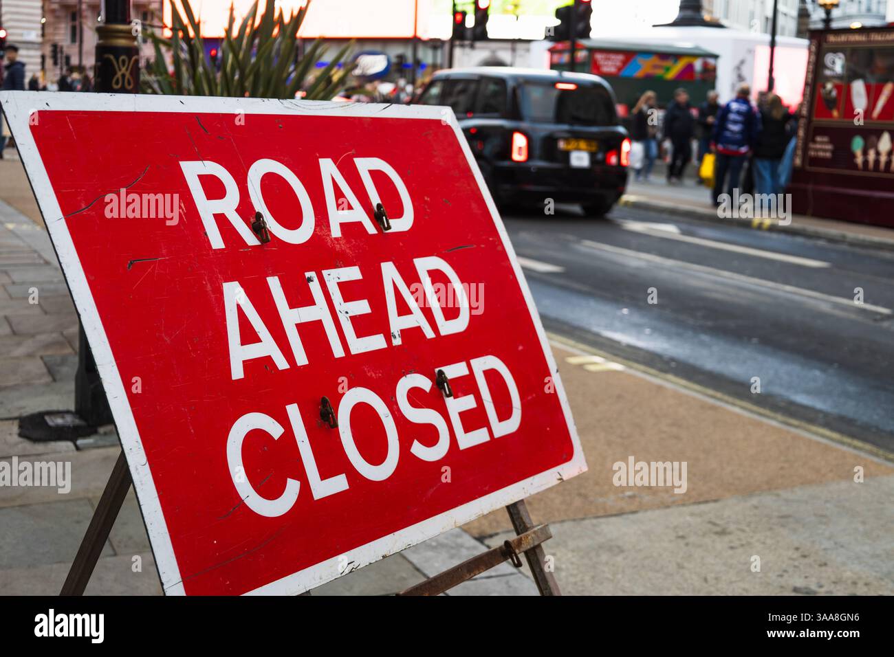 Temporary Road Ahead Closed Sign Placed on Sidewalk with City Traffic ...