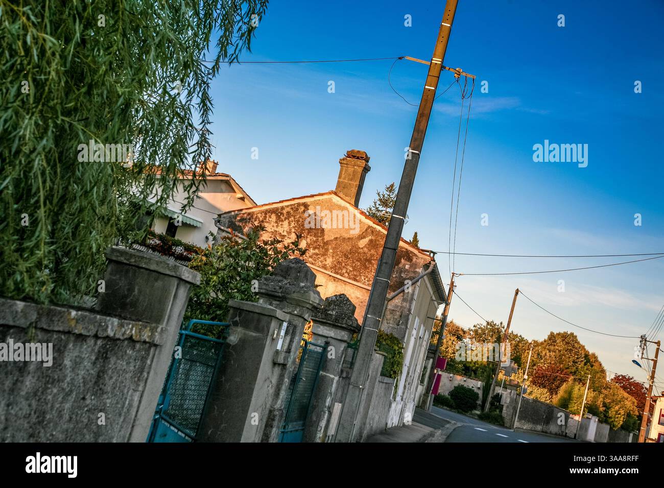 A house with a chimney and a fence in Cognac France. The fence is blue ...