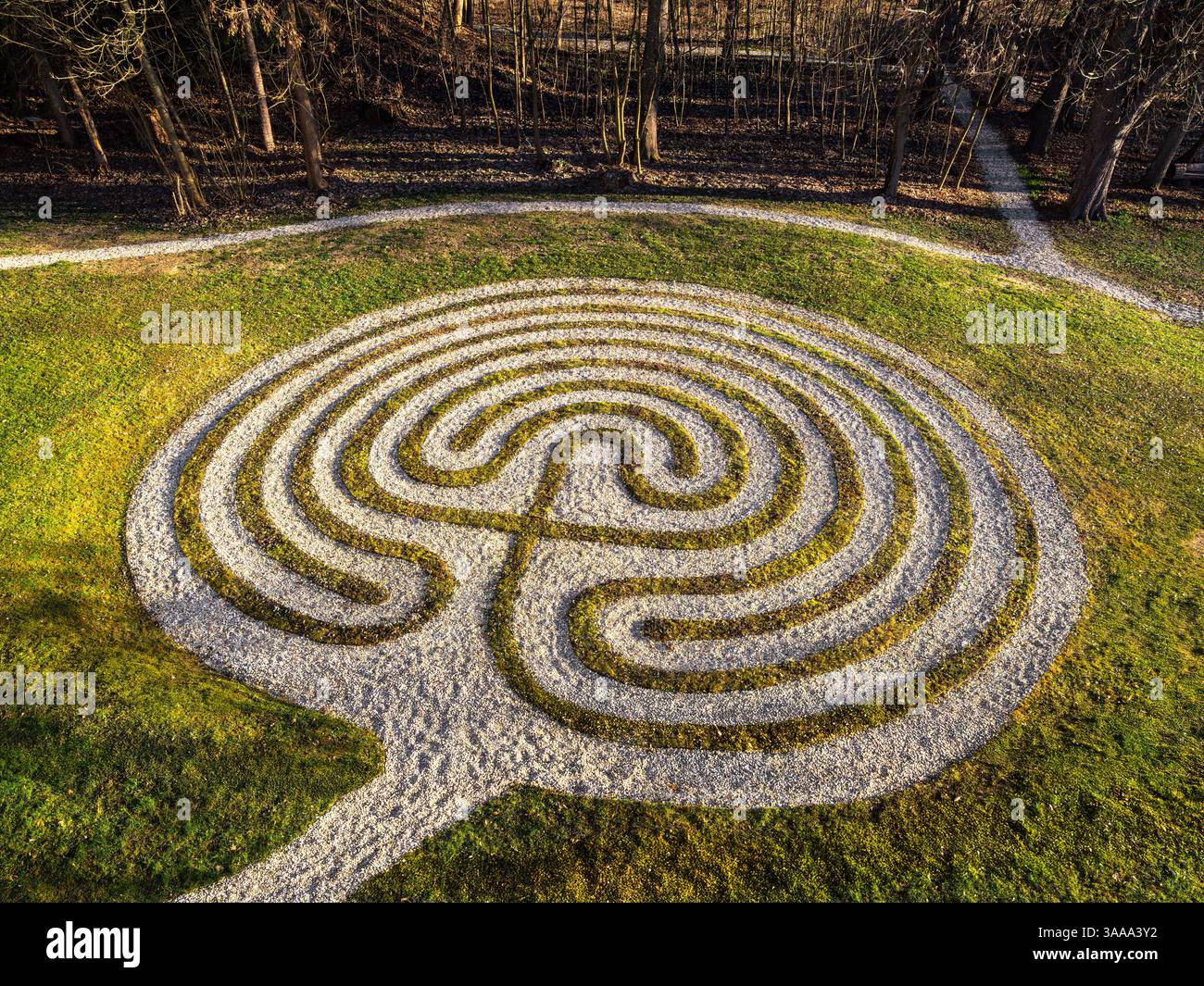 Aerial view of a circular labyrinth made of gravel, surrounded by green ...