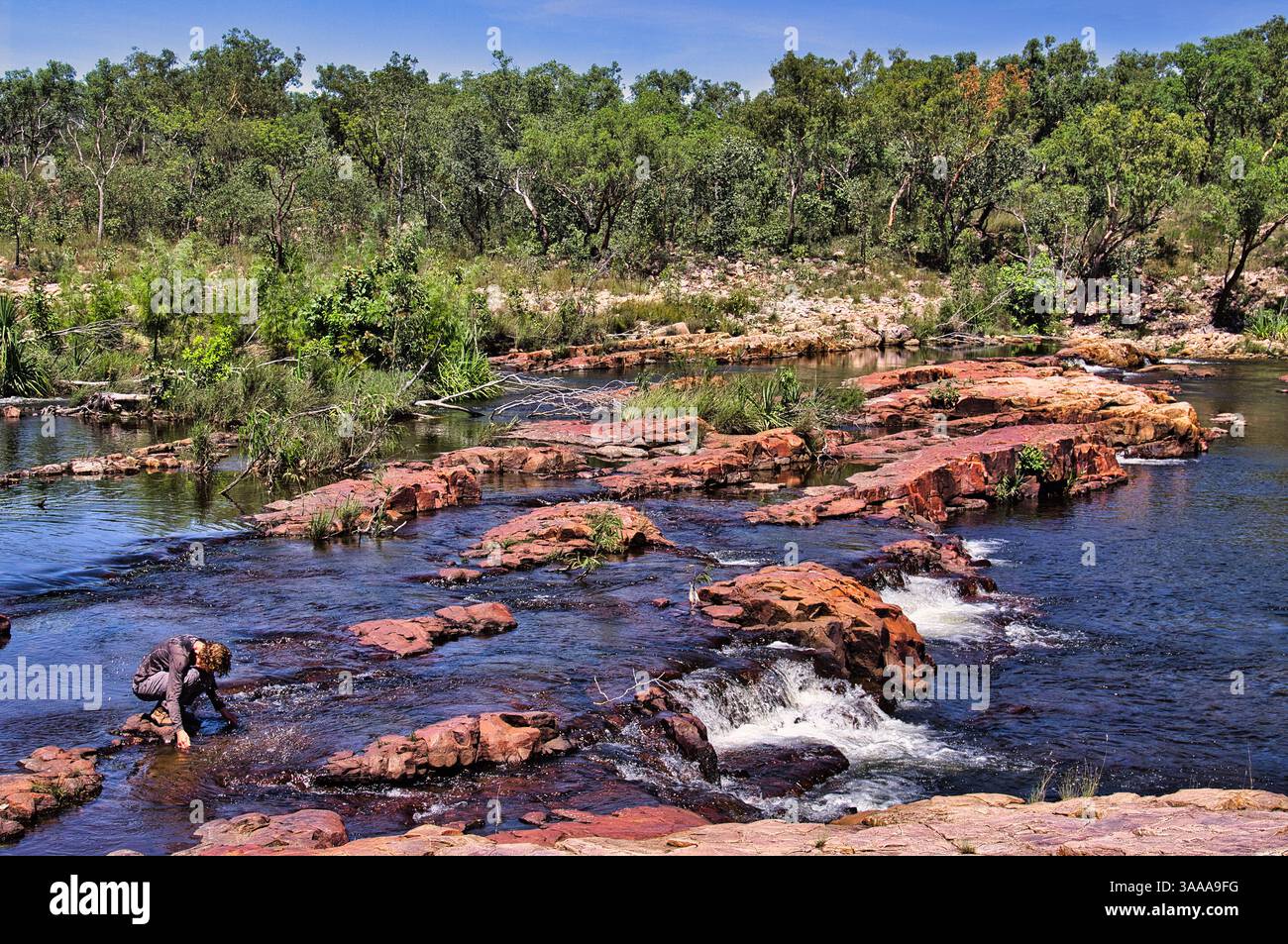 Hiker sprays cool water over herself in the rapids of the Crystal Falls ...
