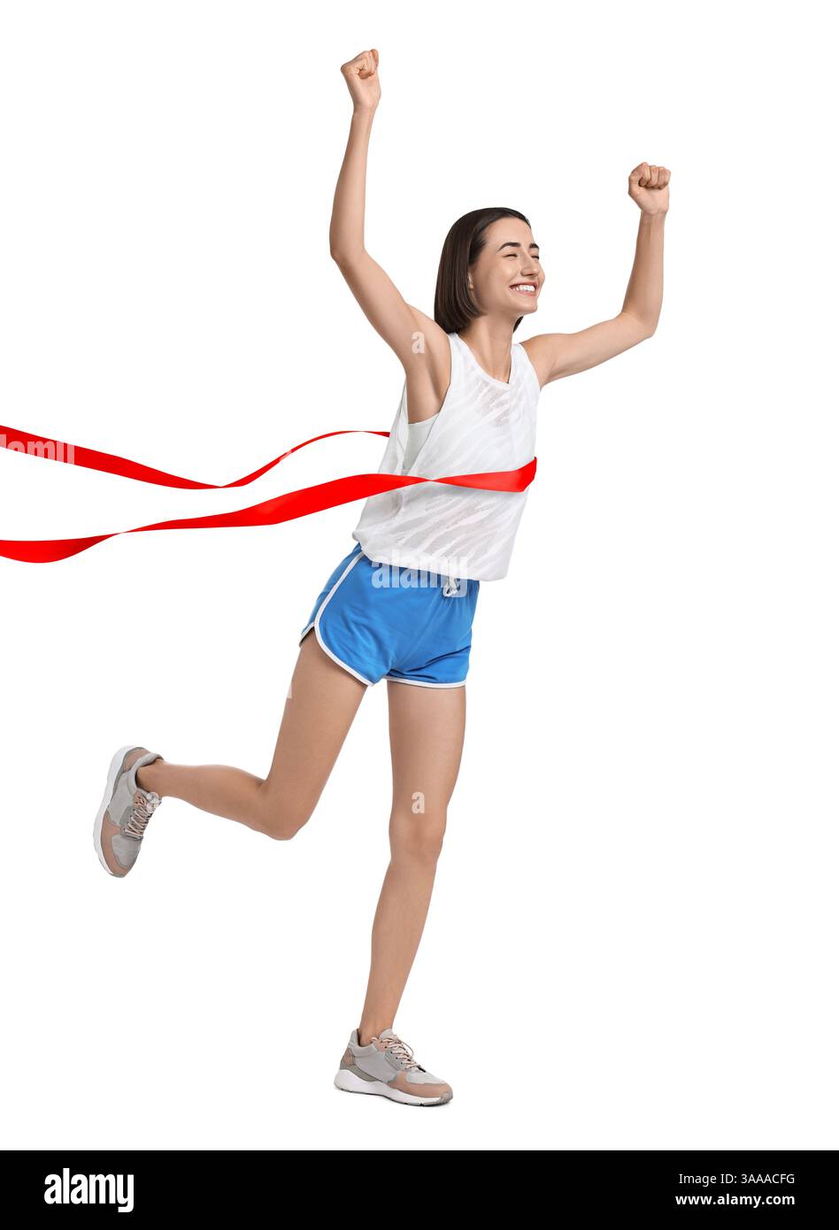 Happy sportswoman crossing red finish line ribbon on white background ...