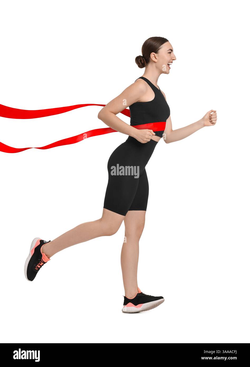 Happy sportswoman crossing red finish line ribbon on white background ...
