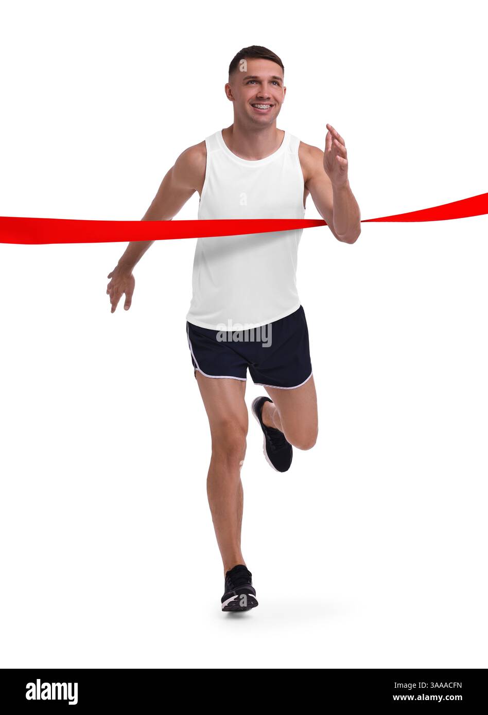 Happy sportsman crossing red finish line ribbon on white background ...