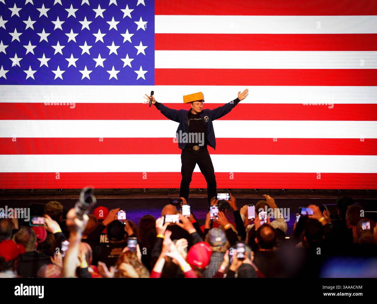 Elon Musk enters the stage wearing a cheesehead during a town hall ...