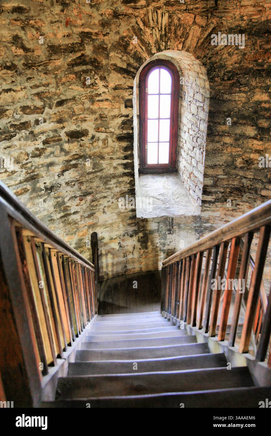 A staircase with a window in the middle. The window is small and has a ...