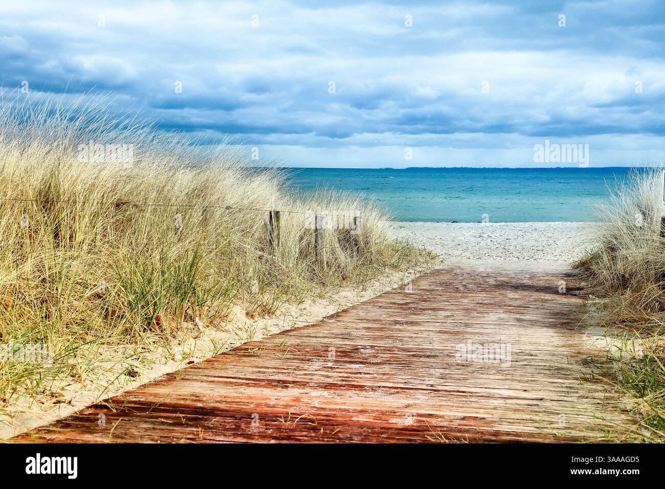 A red wooden boardwalk leading to the beach Baltic Sea in Germany. The ...
