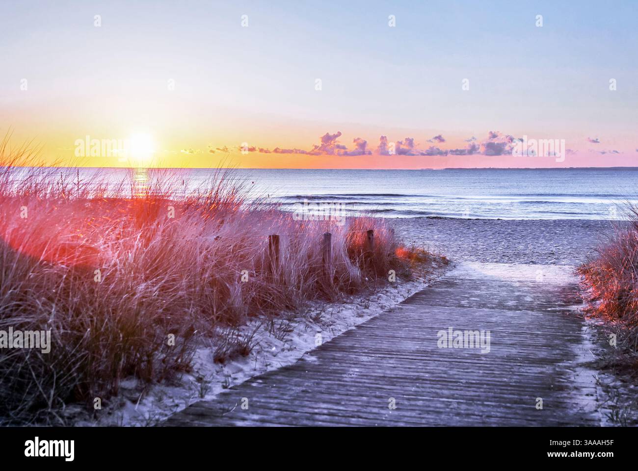 A red wooden boardwalk leading to the beach Baltic Sea in Germany. The ...