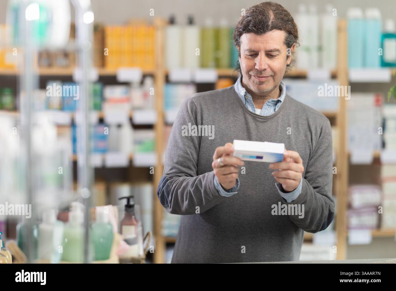 Man choose antifungal ointment in pharmacy, examine packaging Stock ...