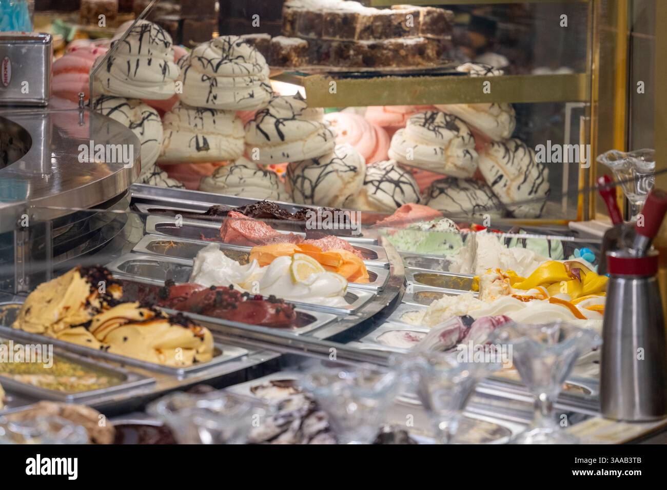 A display of desserts and ice cream in a store in Italy. There are many ...