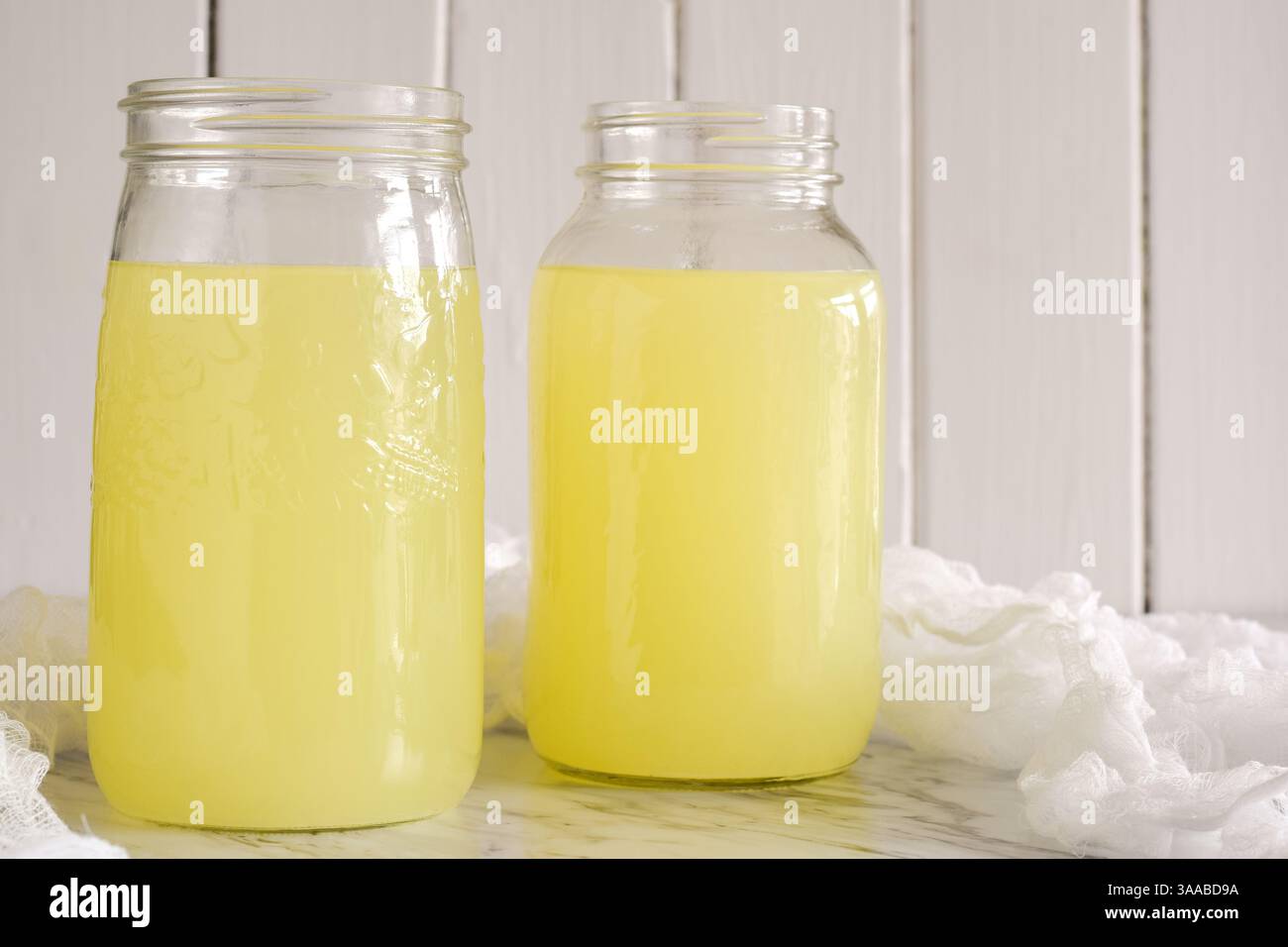 Leftover whey liquid in two glass jars on white countertop Stock Photo ...
