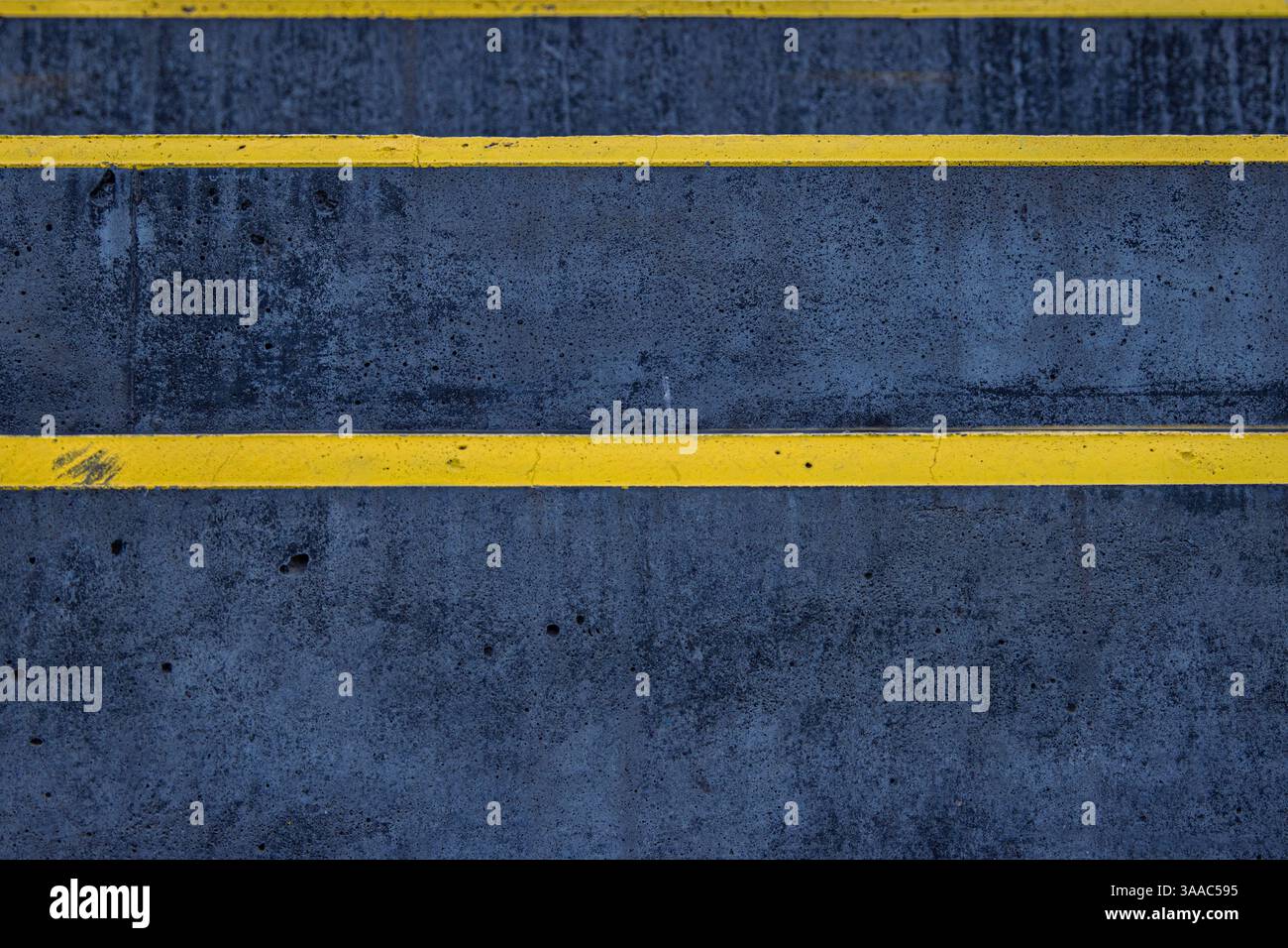 Closeup of a textured asphalt road with weathered yellow stripes on a ...