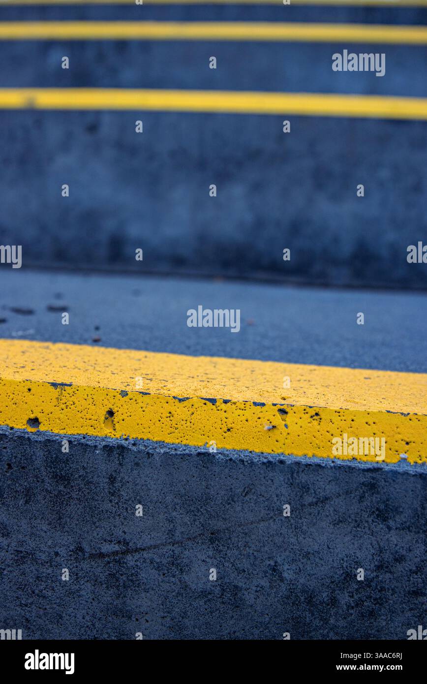 Closeup of a textured asphalt road with weathered yellow stripes on a ...