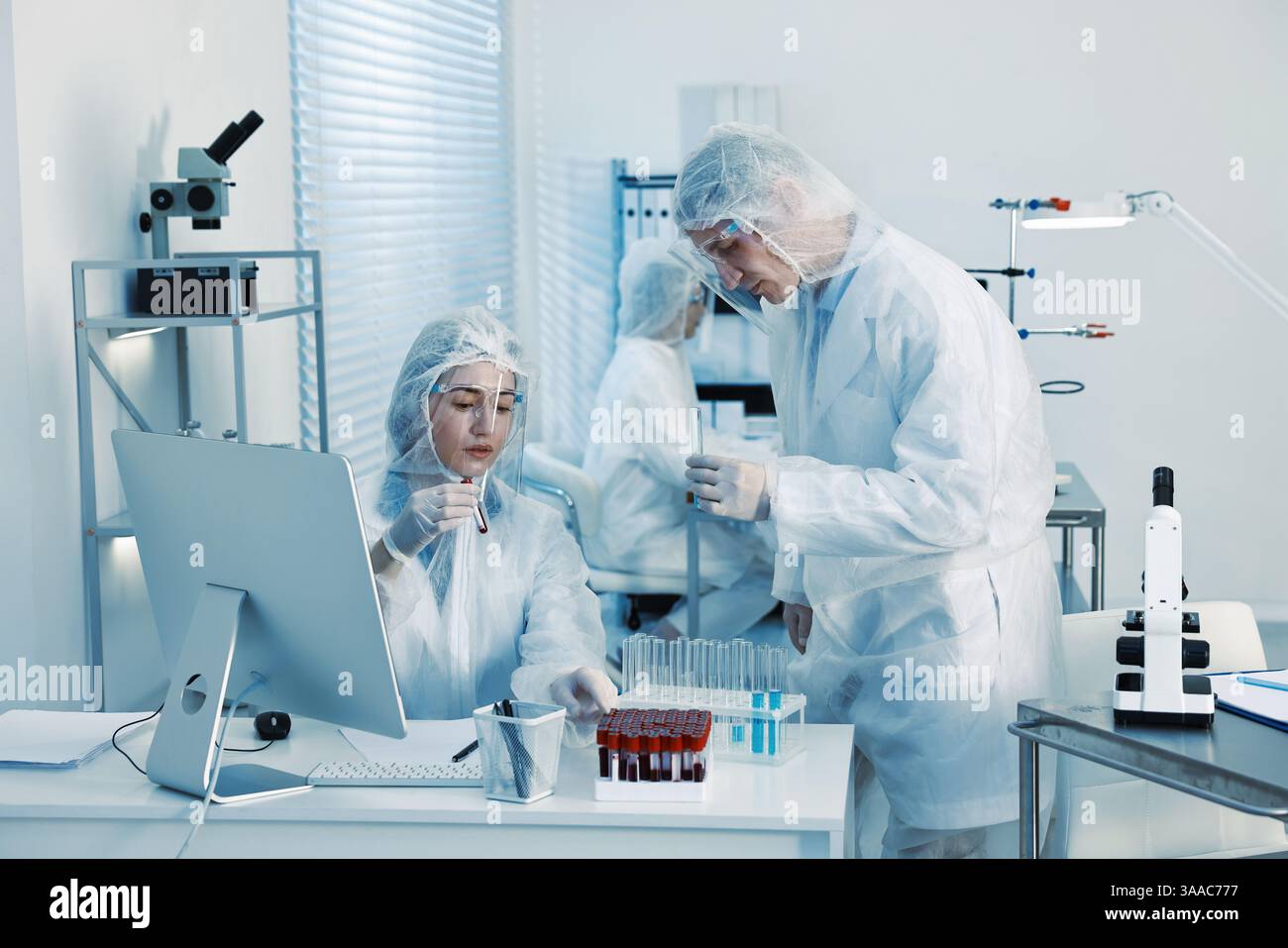 Scientists working with reagents and blood samples in laboratory Stock ...