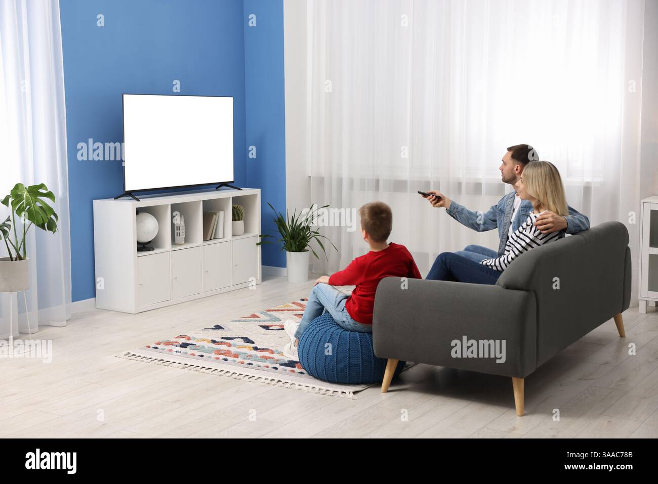 Happy family watching tv together at home Stock Photo - Alamy