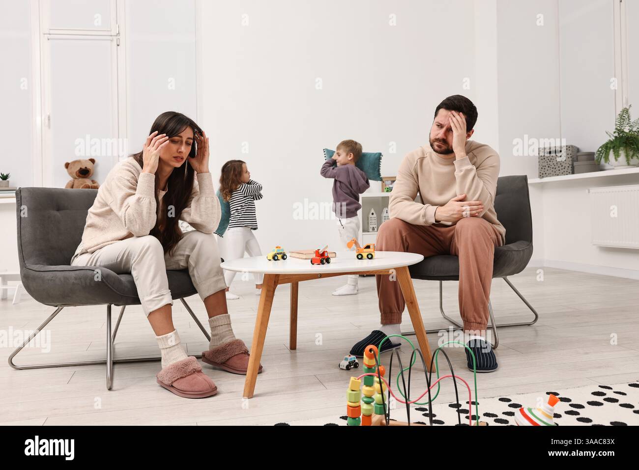 Overwhelmed parents and their naughty children at home Stock Photo - Alamy