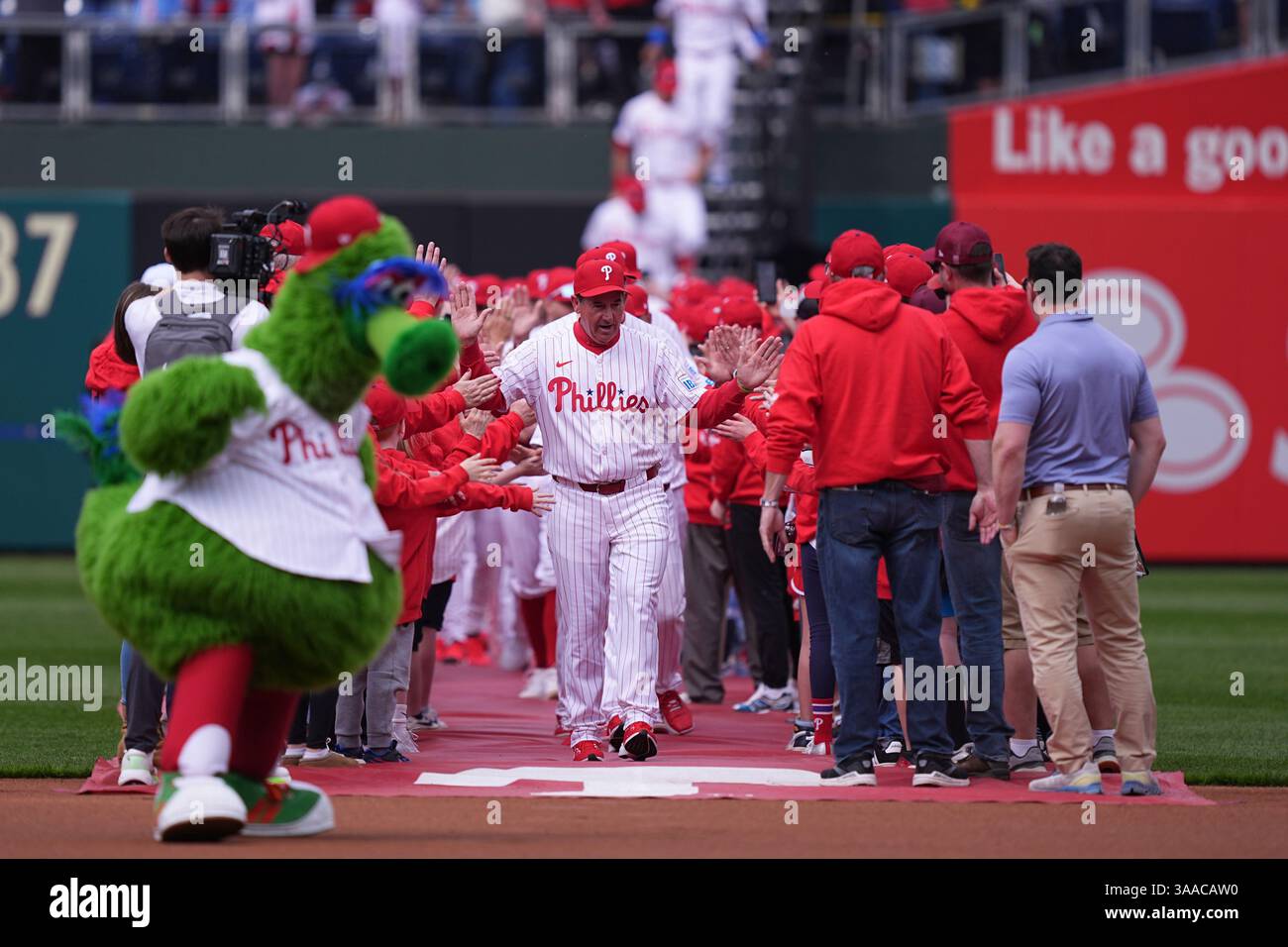 Philadelphia Phillies manager Rob Thomson, center, and the team walk ...