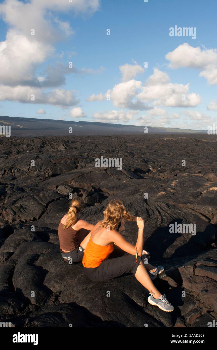 Jan 8, 2015 - Hawaii, U.S. - Girls sitting over the Black lava ...